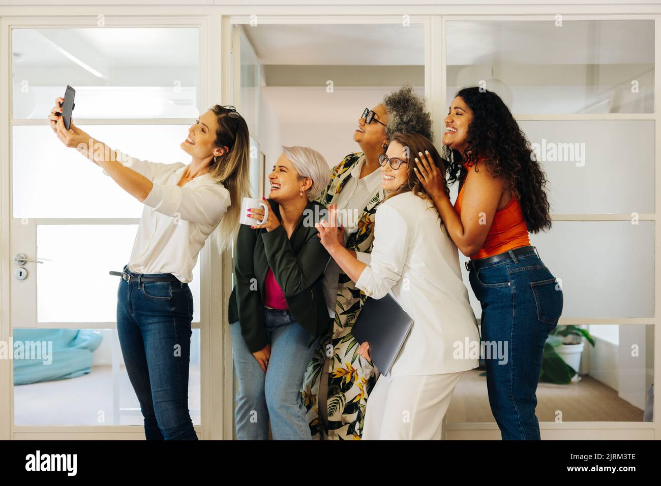 Multicultural businesspeople smiling cheerfully while taking a selfie ... Multicultural businesspeople smiling cheerfully while taking a selfie ...
