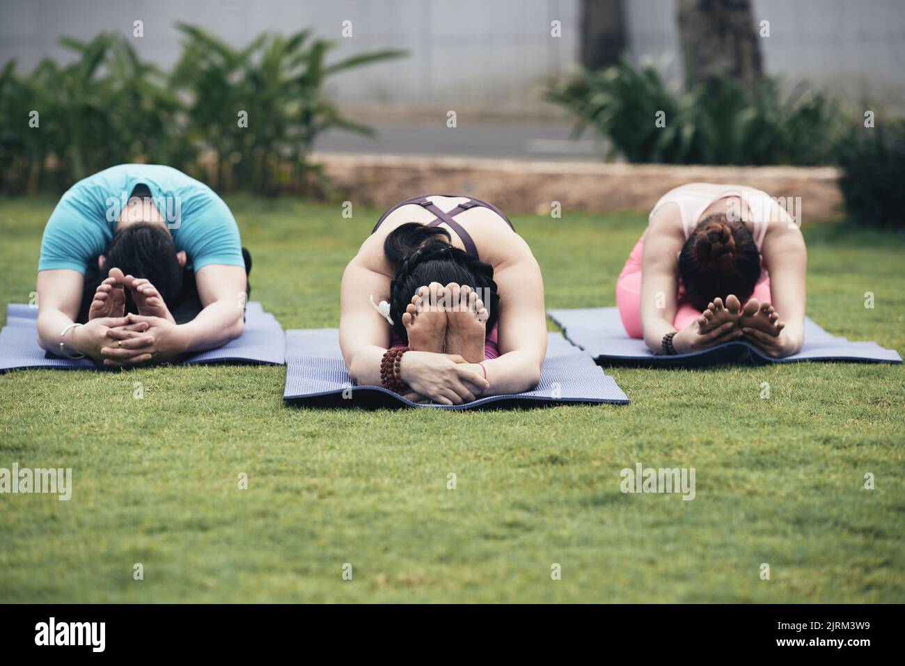 Flexible yuong people stretching forward and lying on their legs Stock ...