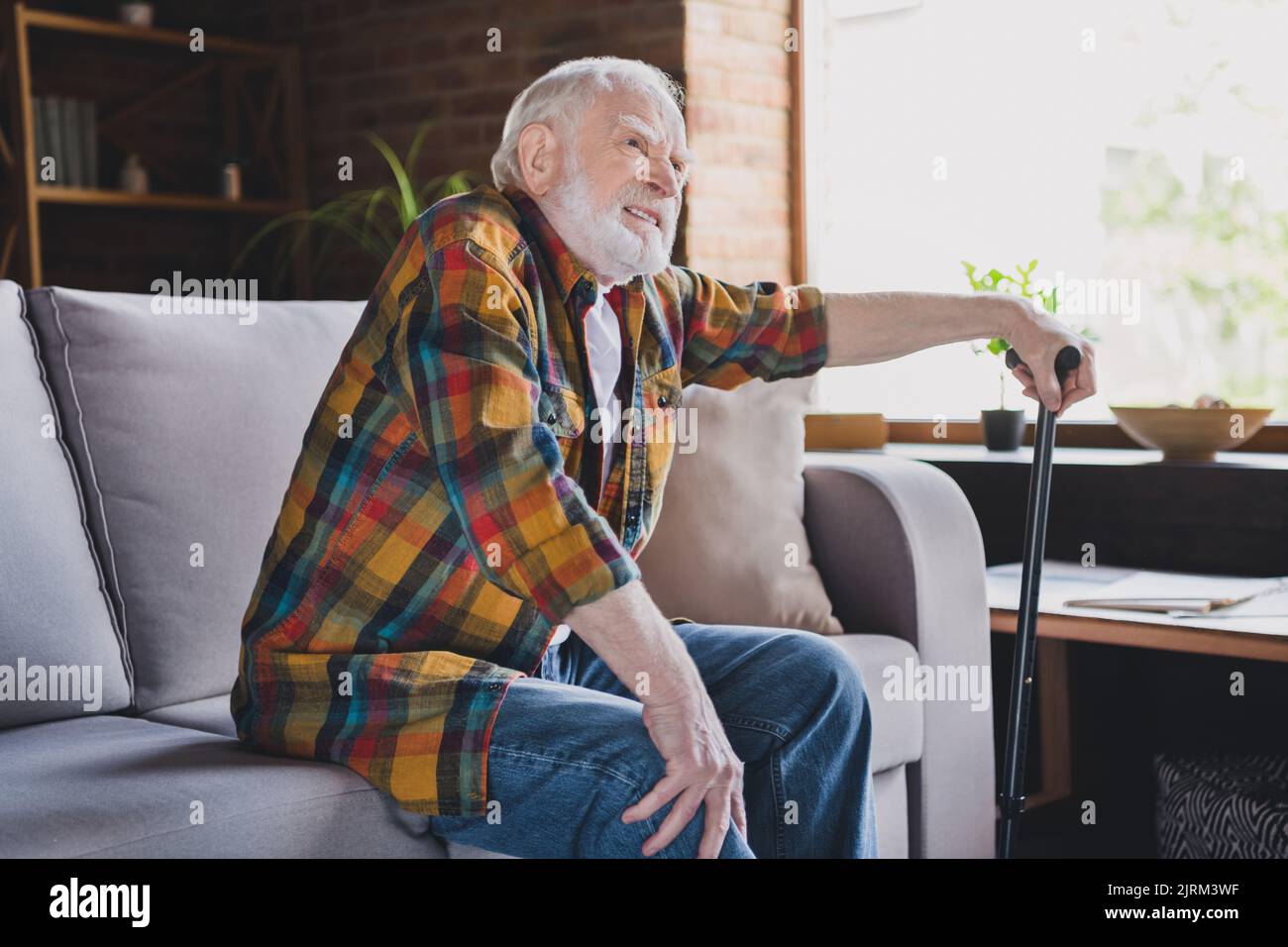 Photo of sad angry retired man dressed plaid shirt having knee ache holding nursery cane trying ...