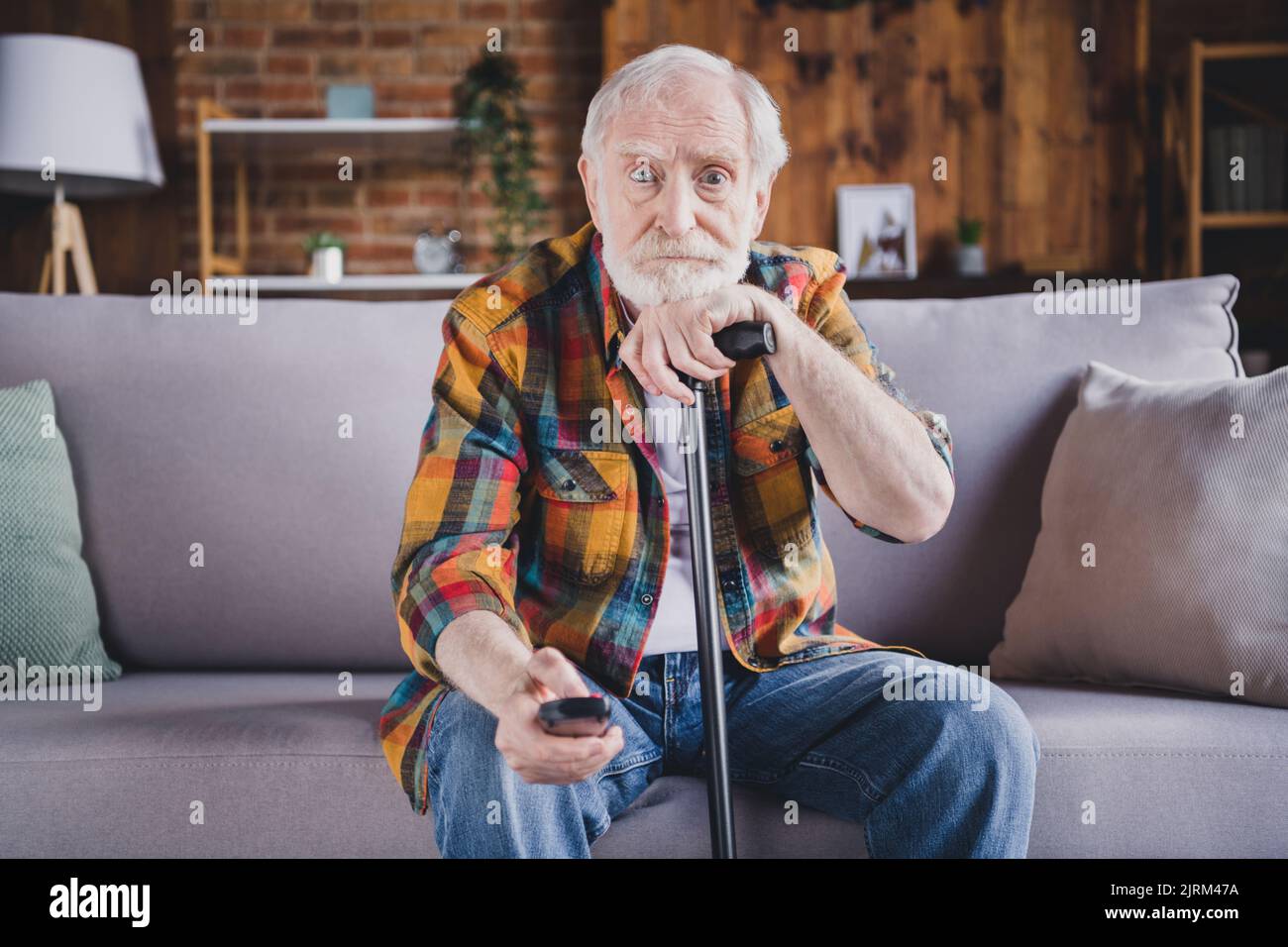 Photo of stressed sad retired man dressed plaid shirt sitting couch ...