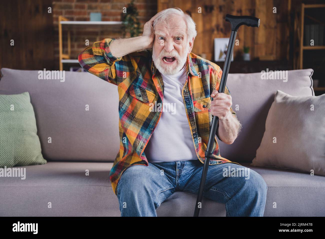 Photo of furious angry retired man dressed plaid shirt sitting couch ...