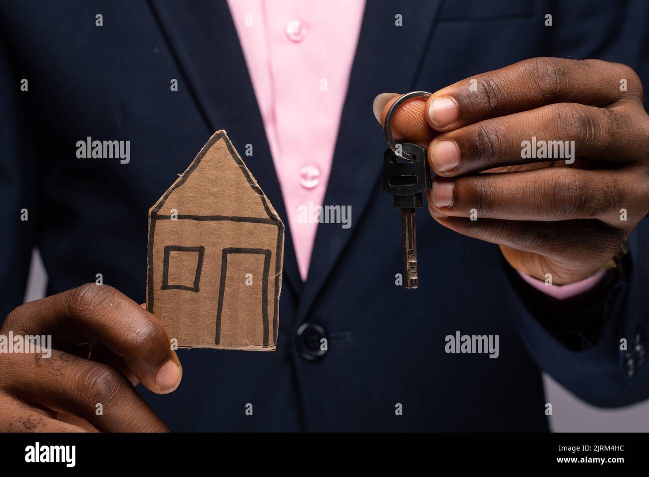 african man holding cardboard house and key Stock Photo - Alamy
