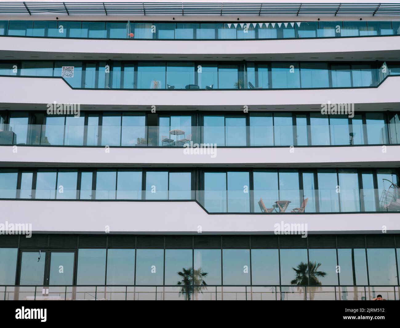 New build seaside seafront apartments with windows reflecting blue sky ...