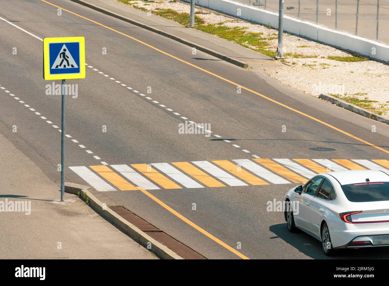 Pedestrian crossing with a road sign through the city road, the white ...