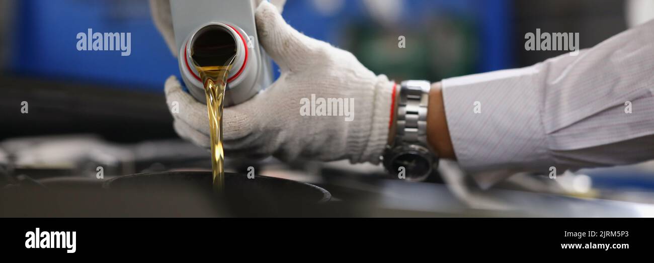 Master repairman pouring engine oil under hood of car closeup Stock ...