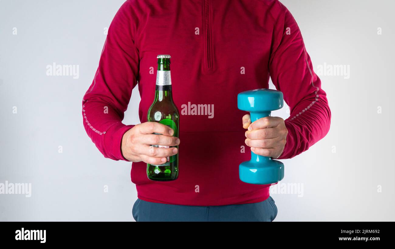 A man makes a choice between a bottle of beer and a workout with ...