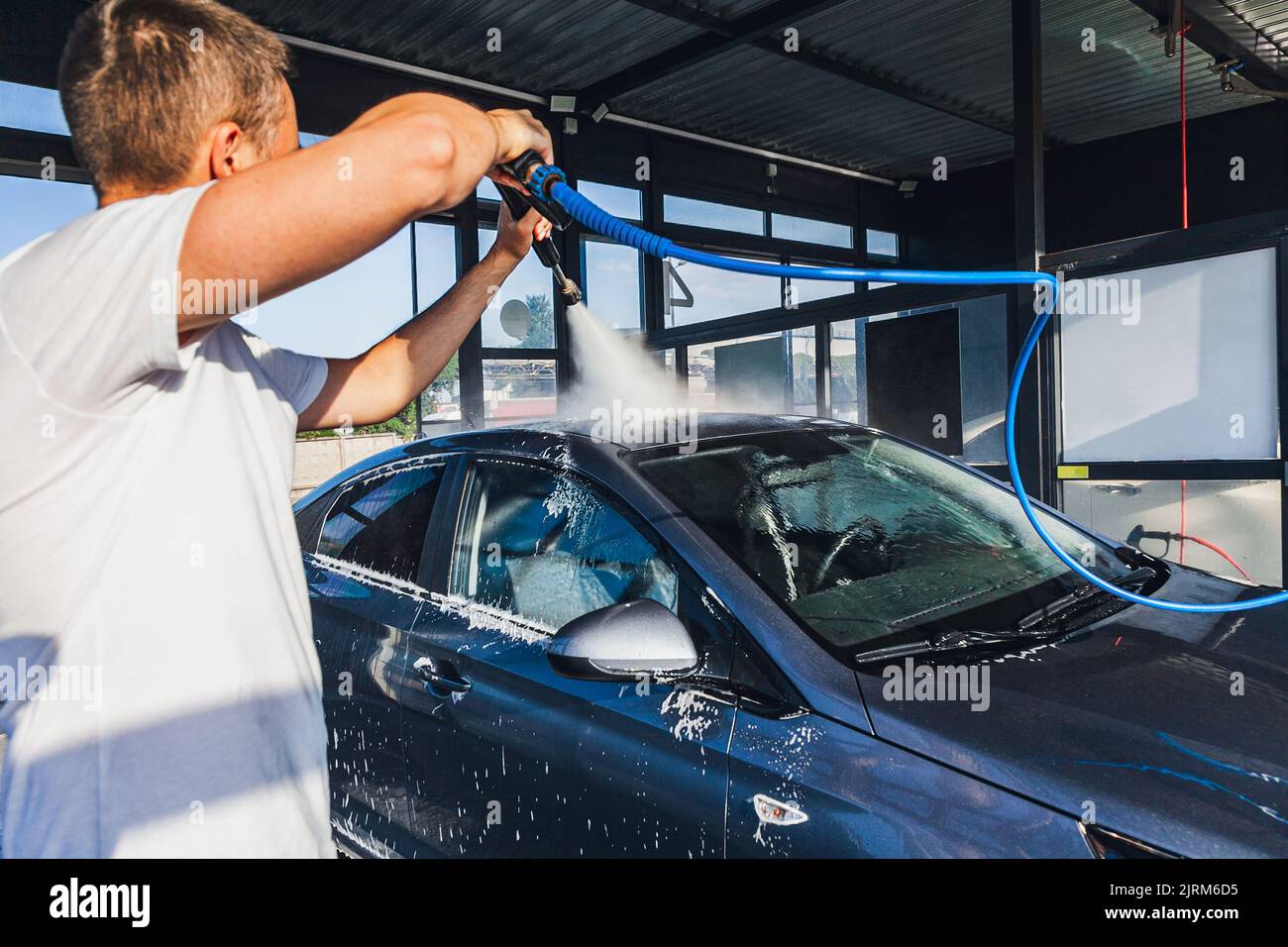 Man using water hose wash hi-res stock photography and images - Alamy