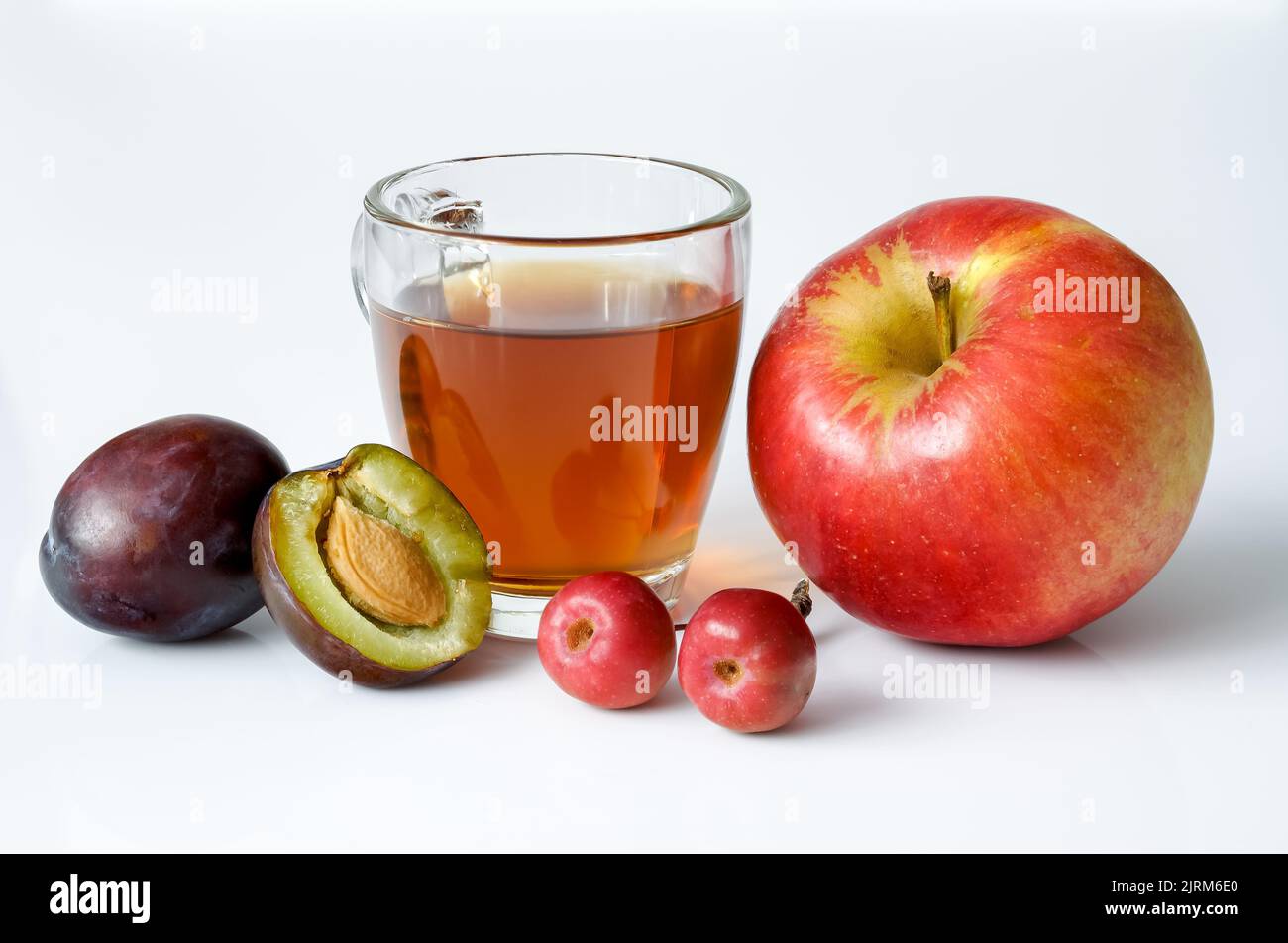 fruit juice in a glass, plum, apple on a white background, minimal ...