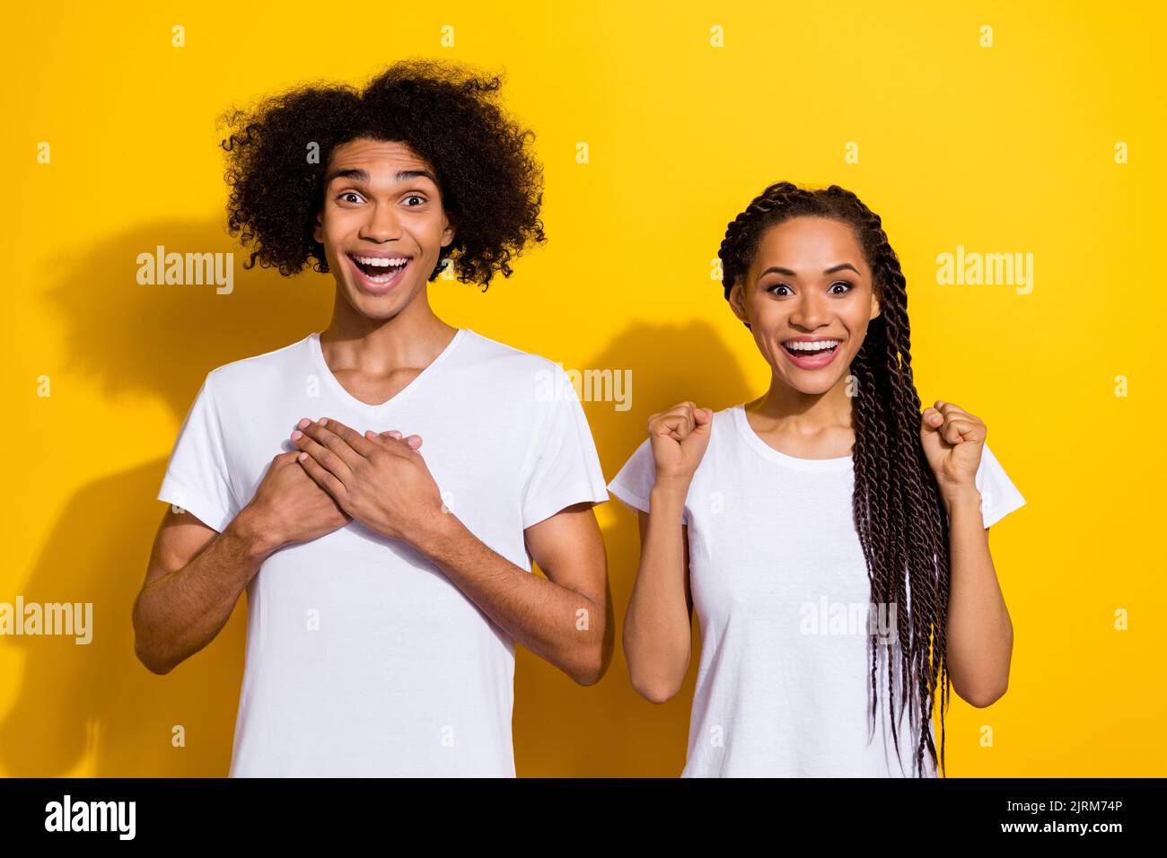 Photo of two funny positive partners raise fists hands touch chest ...