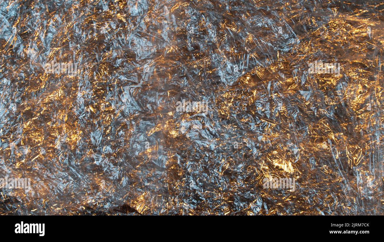 Texture crumpled food film drenched in warm light with gold Stock Photo ...