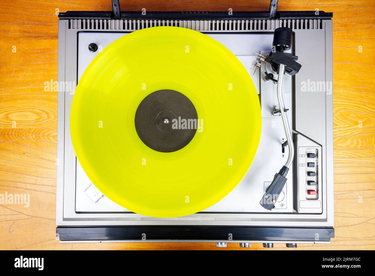 Vintage turntable vinyl record player with yellow vinyl on a table ...