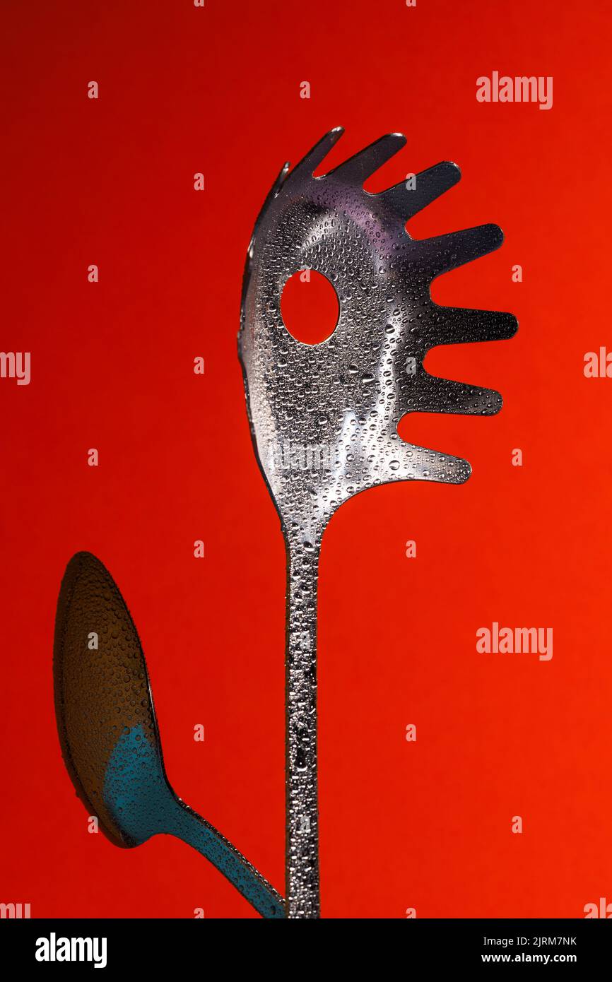A vertical shot of kitchen utensil set isolated on a bold orange ...