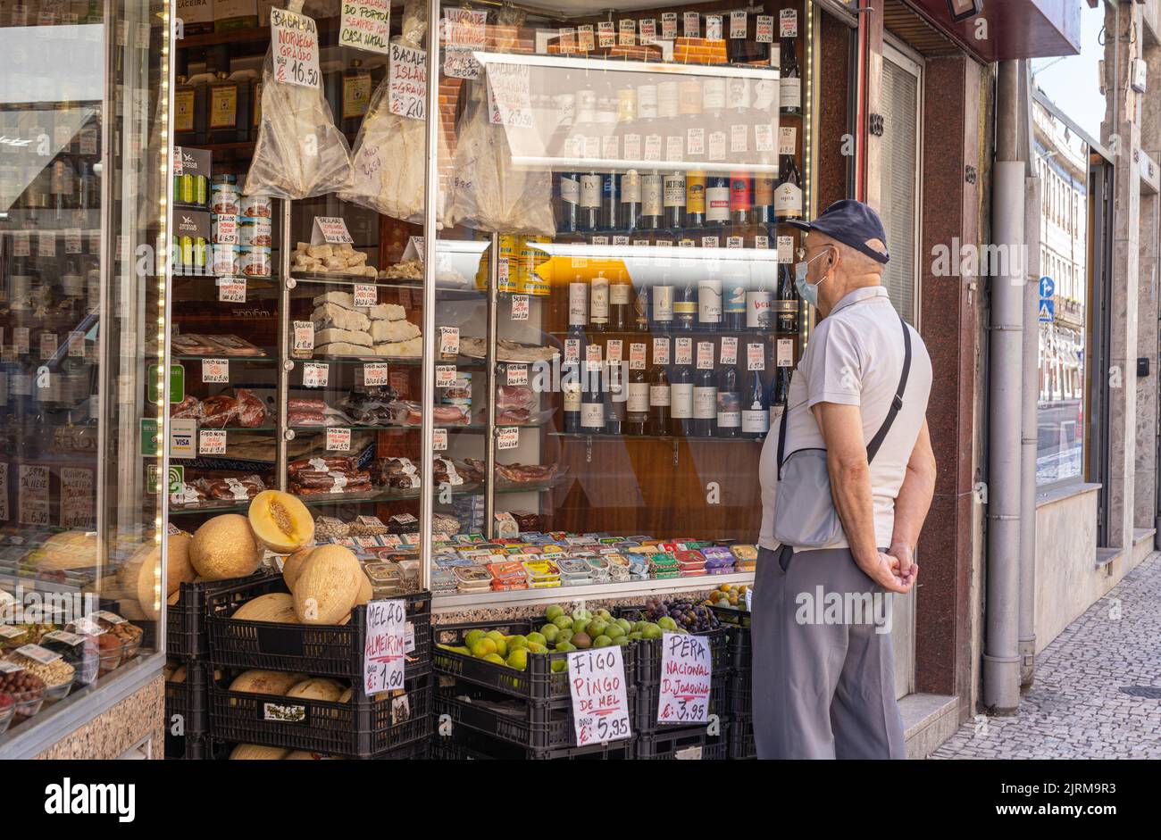 OPORTO, PORTUGAL - 28.07.2022: Man looking at traditional food store ...