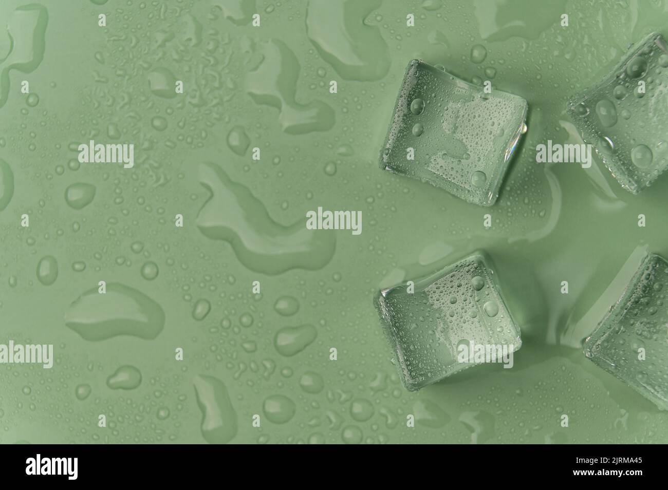 Ice cubes from above on a Green background Stock Photo - Alamy