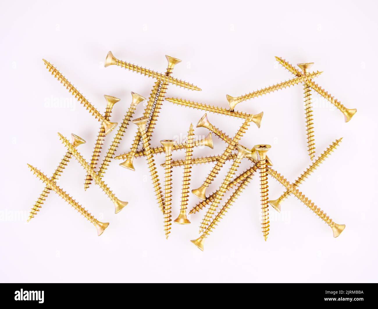 Bunch of gold self-tapping screws on a white background Stock Photo - Alamy