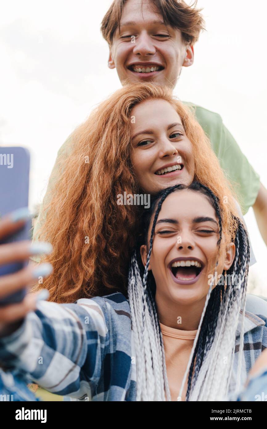 Three teenagers having fun and taking selfie, enjoying a day outdoors ...