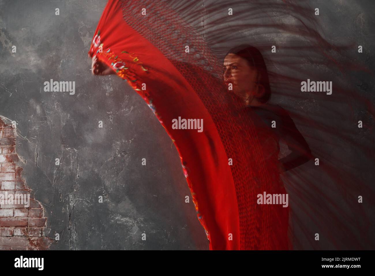 Young adult spanish woman dancing flamenco on gray vintage studio ...