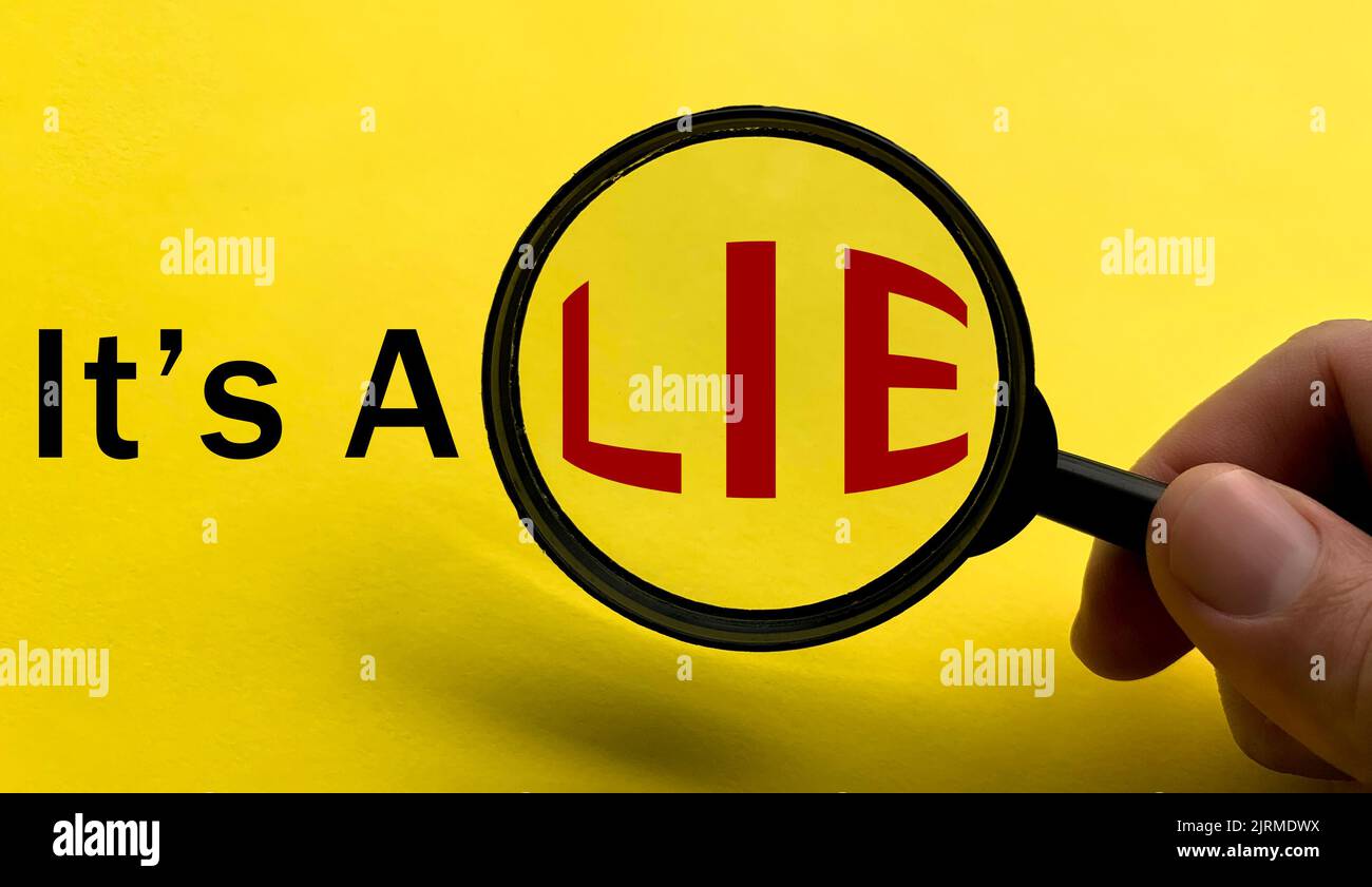 It's a lie text on yellow cover with hand holding magnifying glass. Scamming and fraud concept ...