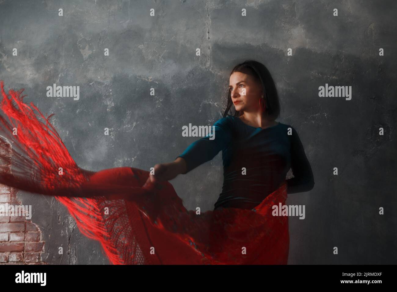 Young adult spanish woman dancing flamenco on gray vintage studio ...