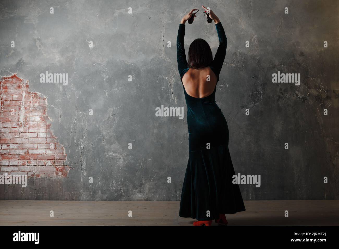 Young adult spanish woman dancing flamenco on gray vintage studio ...