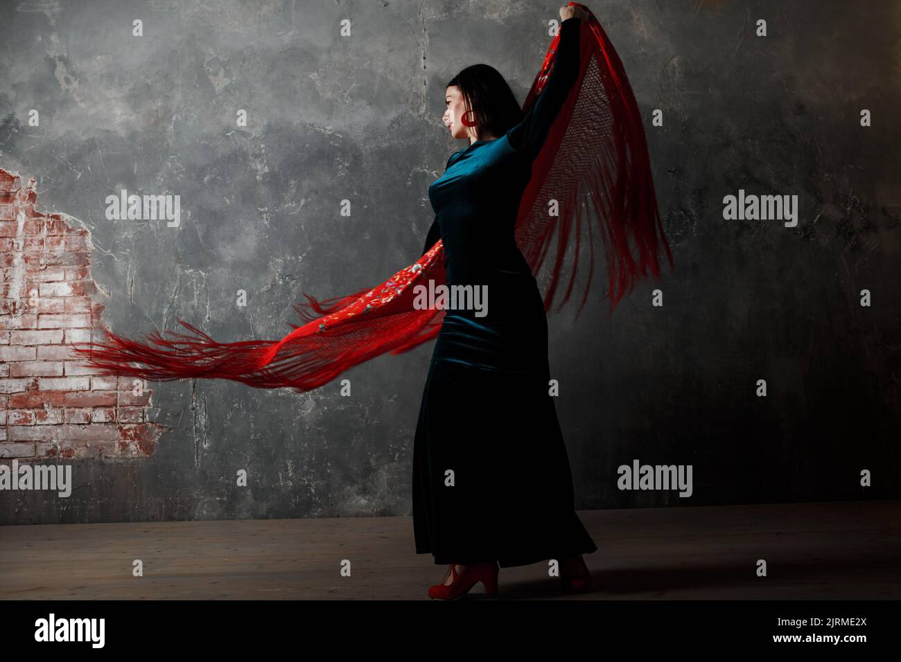 Young adult spanish woman dancing flamenco on gray vintage studio ...