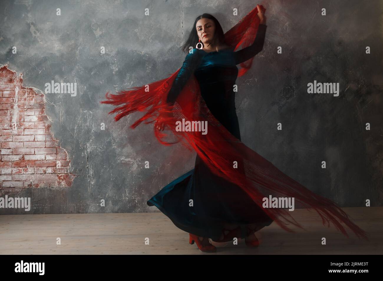 Young adult spanish woman dancing flamenco on gray vintage studio ...