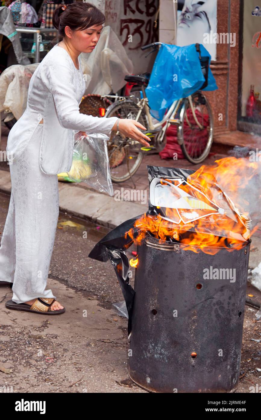 Vietnamese lady burning rubbish in street market, Hai Phong, Vietnam ...