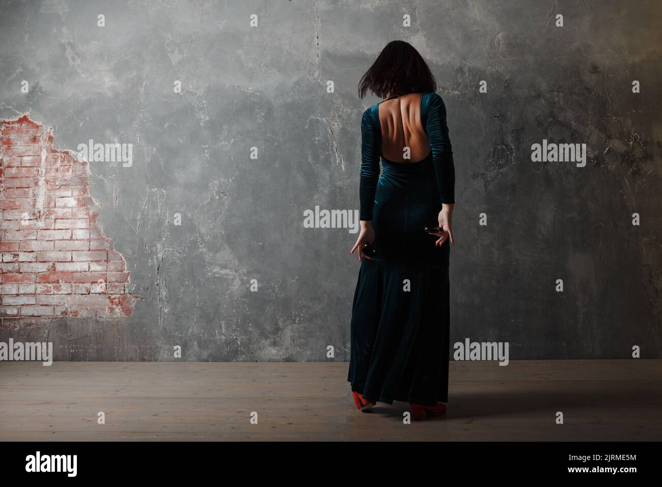Young adult spanish woman dancing flamenco on gray vintage studio ...