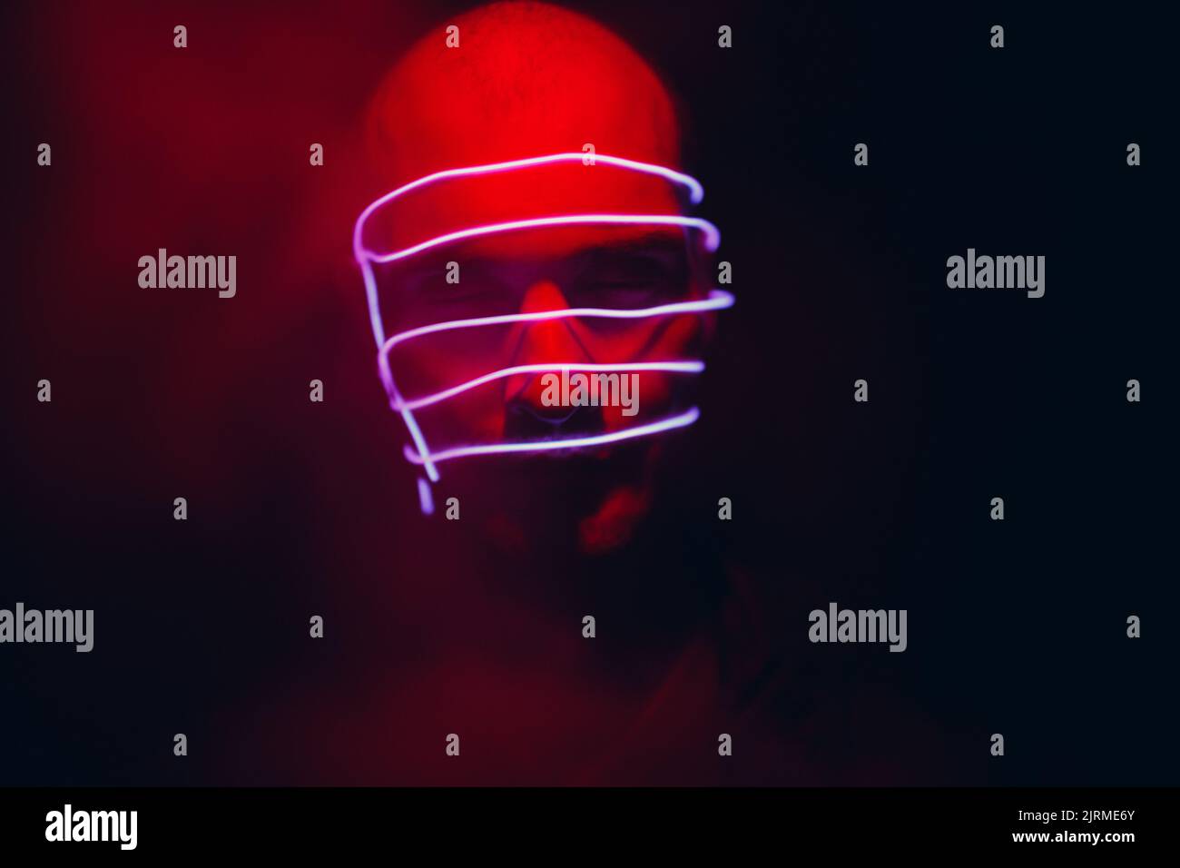 Portrait of man with neon glow lines on his face. Concept cyberpunk and ...