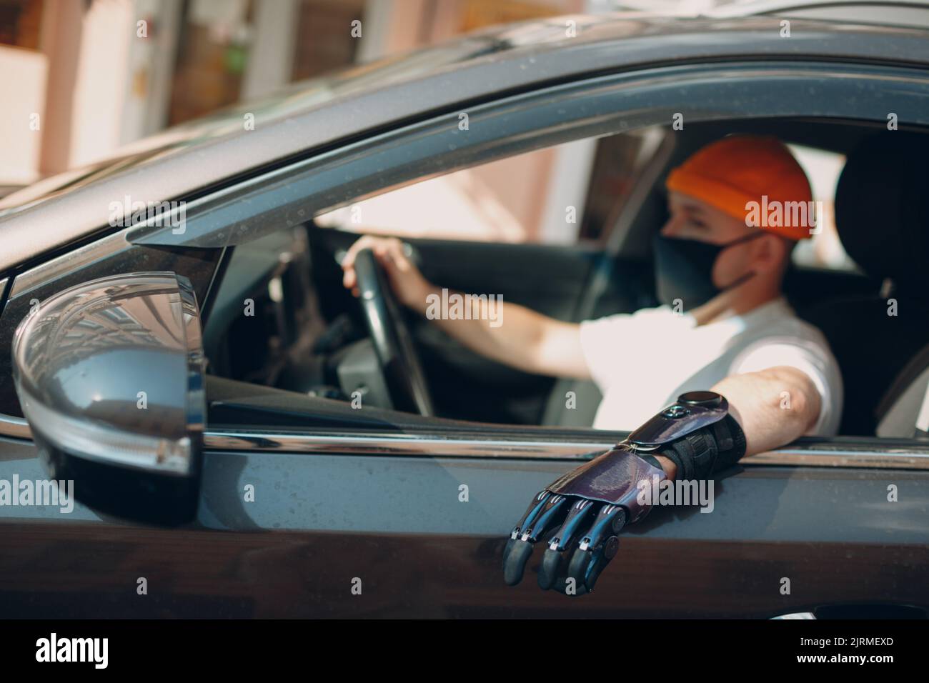 Young disabled man driver with artificial prosthetic hand driving ...