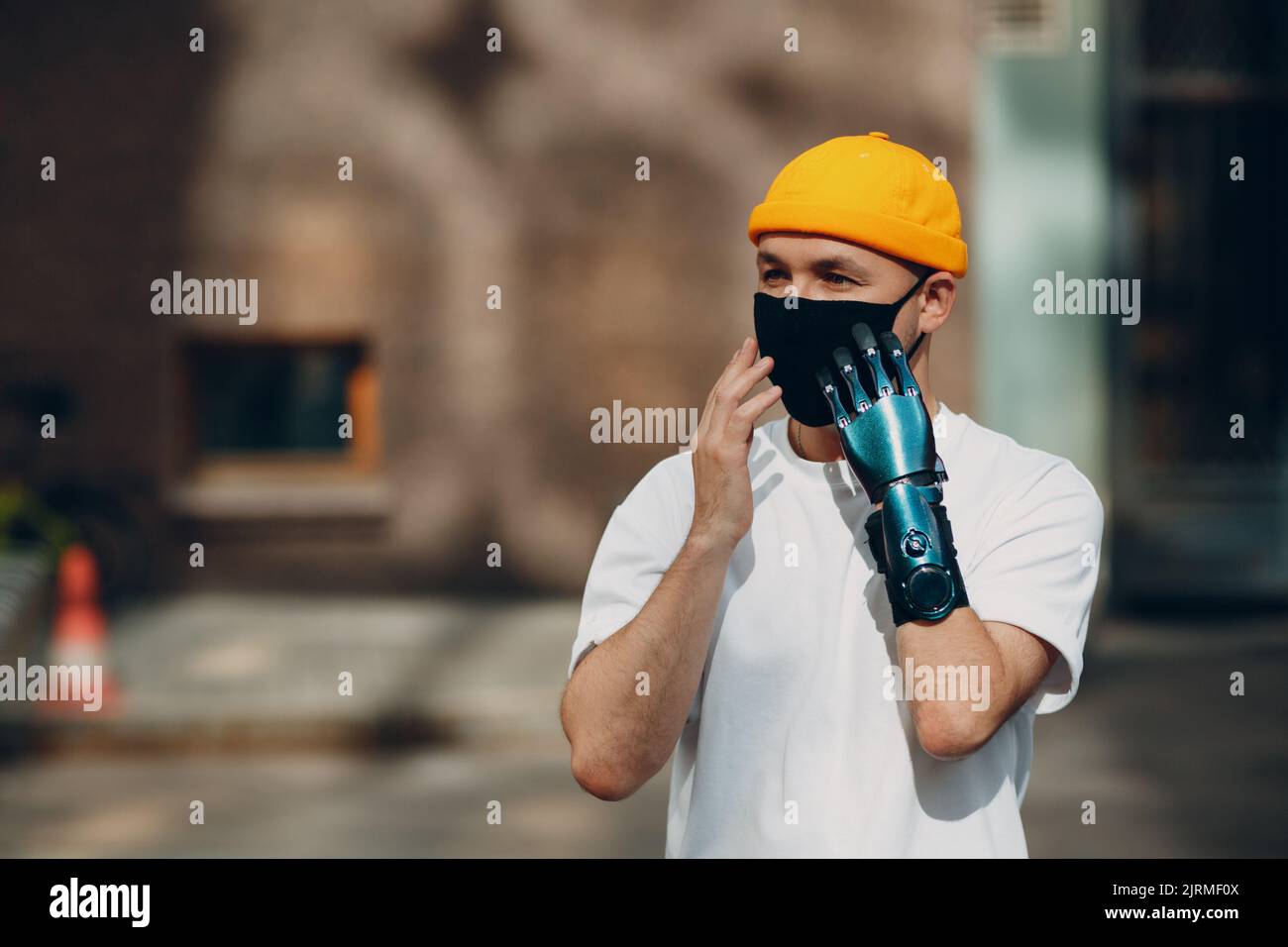 Young disabled man with artificial prosthetic hand wearing medical ...