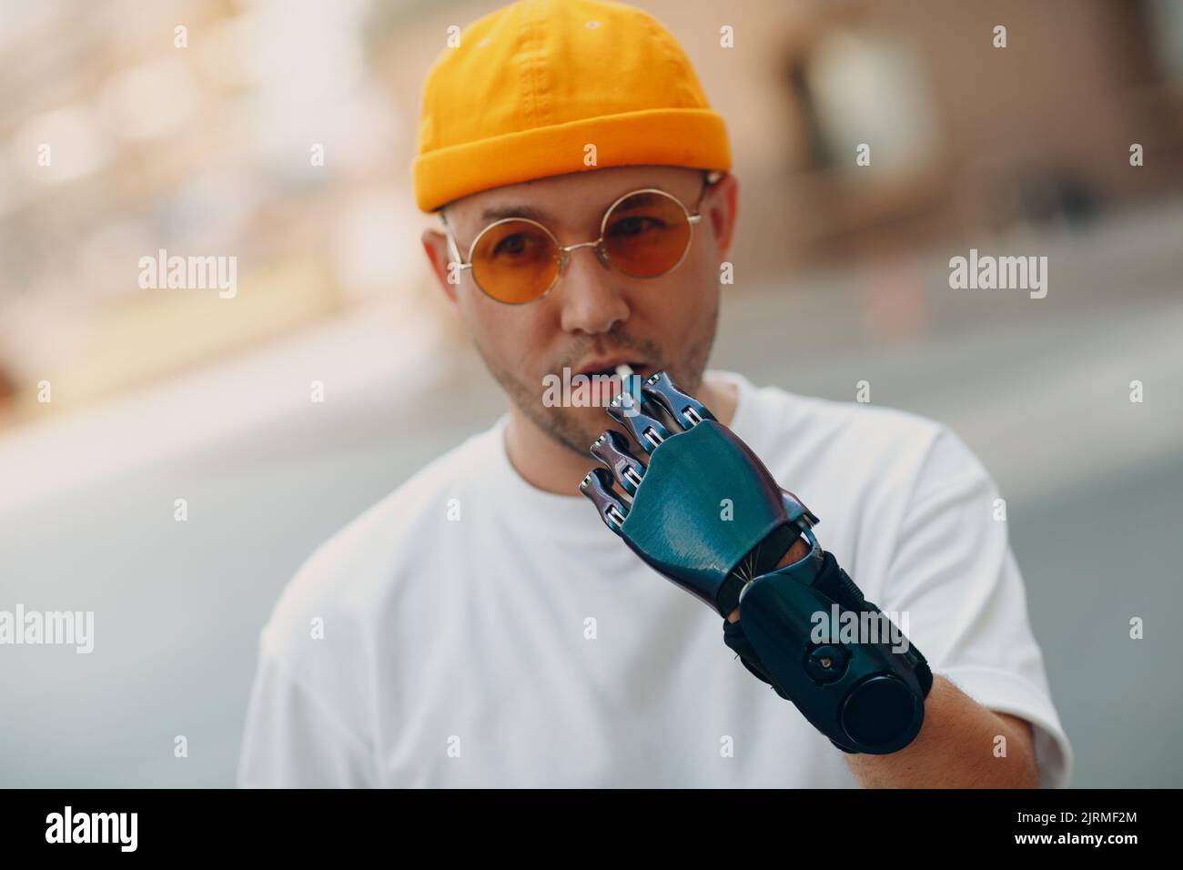 Young disabled man smoke electronic cigarette with artificial ...