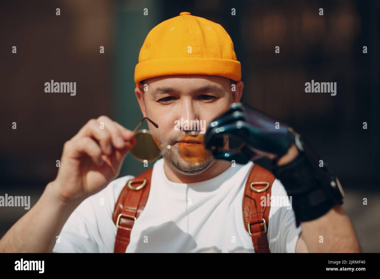 Young disabled man portrait put on yellow glasses with artificial ...
