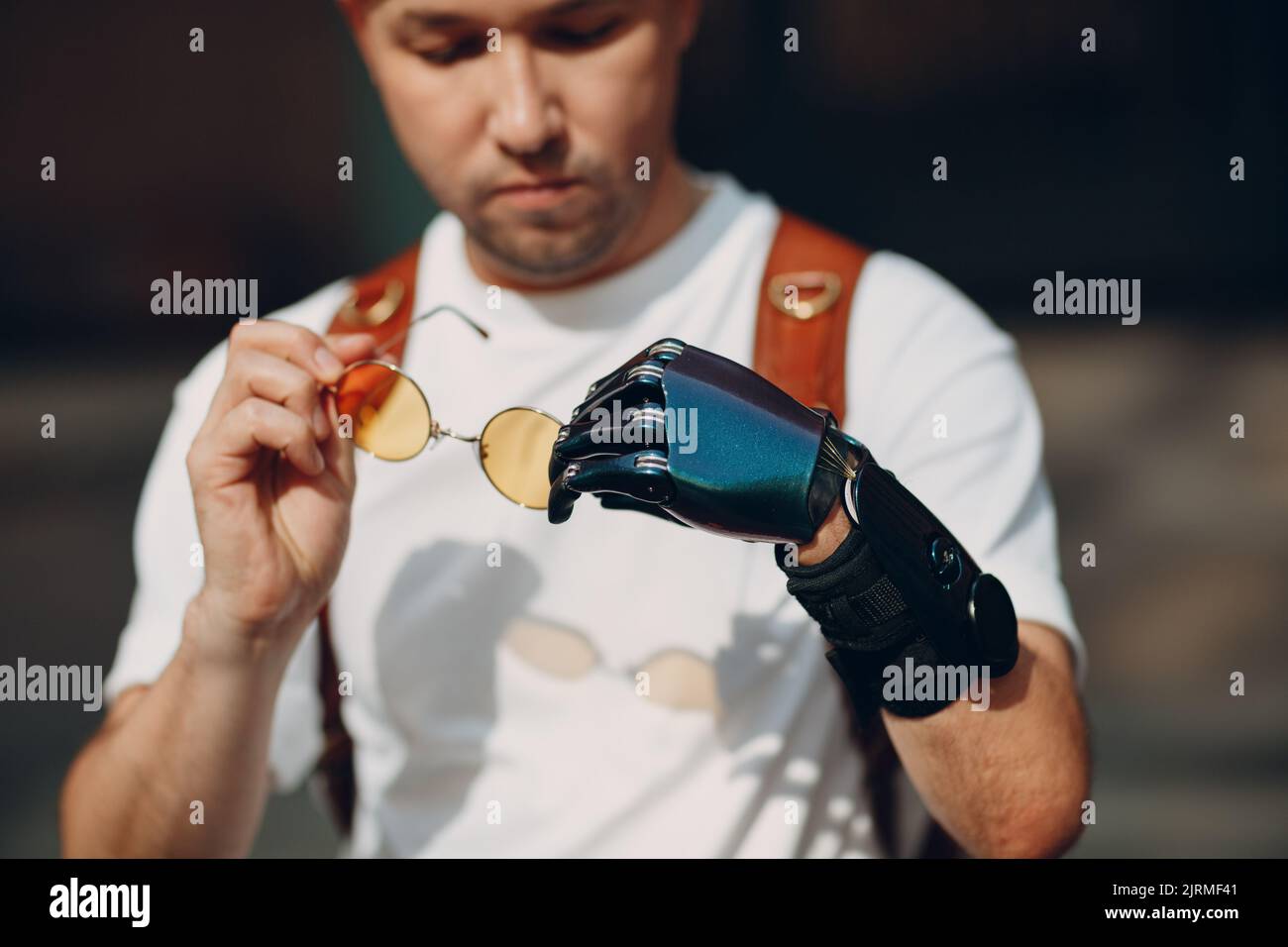 Young disabled man portrait put on yellow glasses with artificial ...