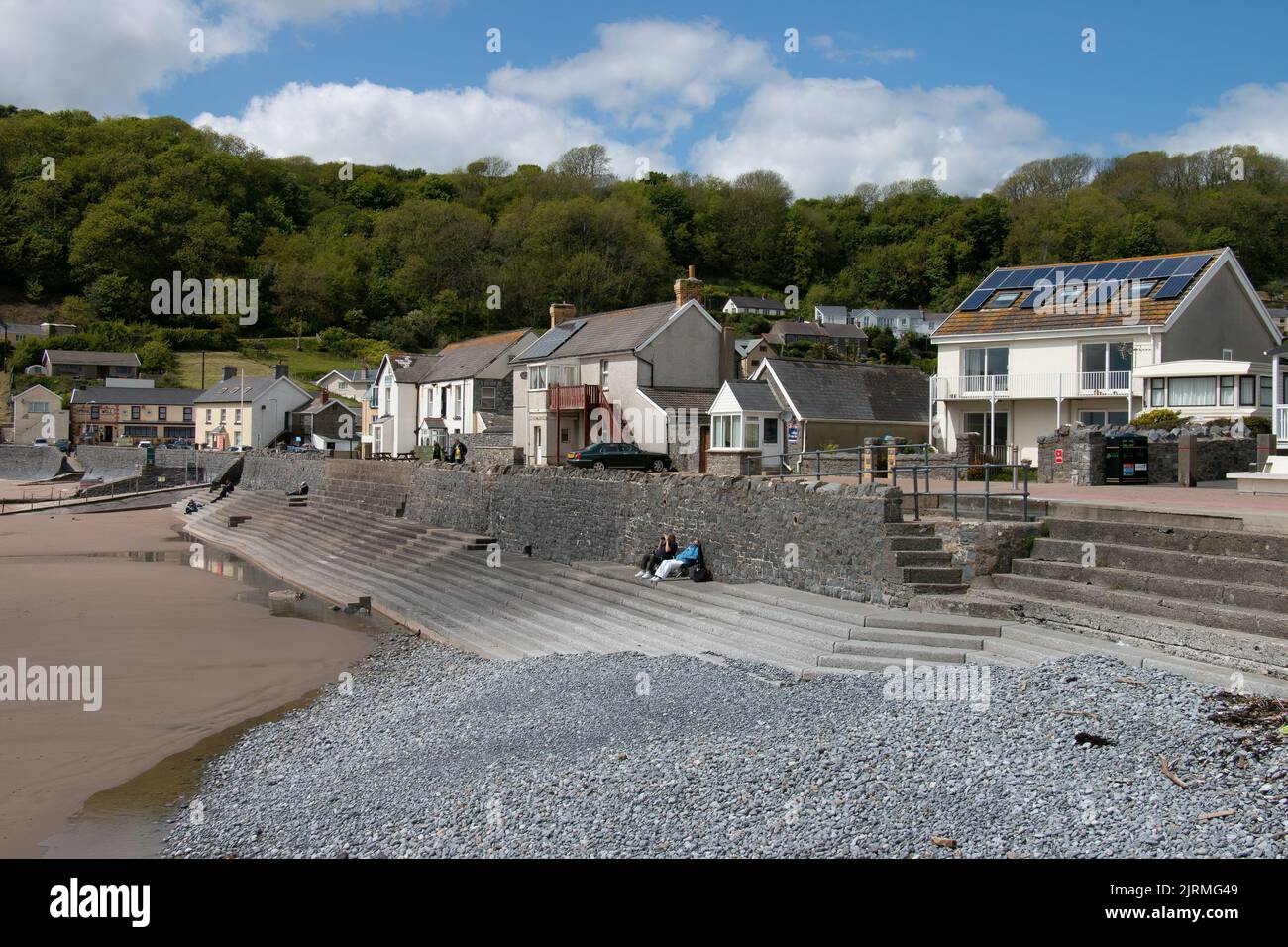 The two people resting on the stairs before the seaside buildings of ...