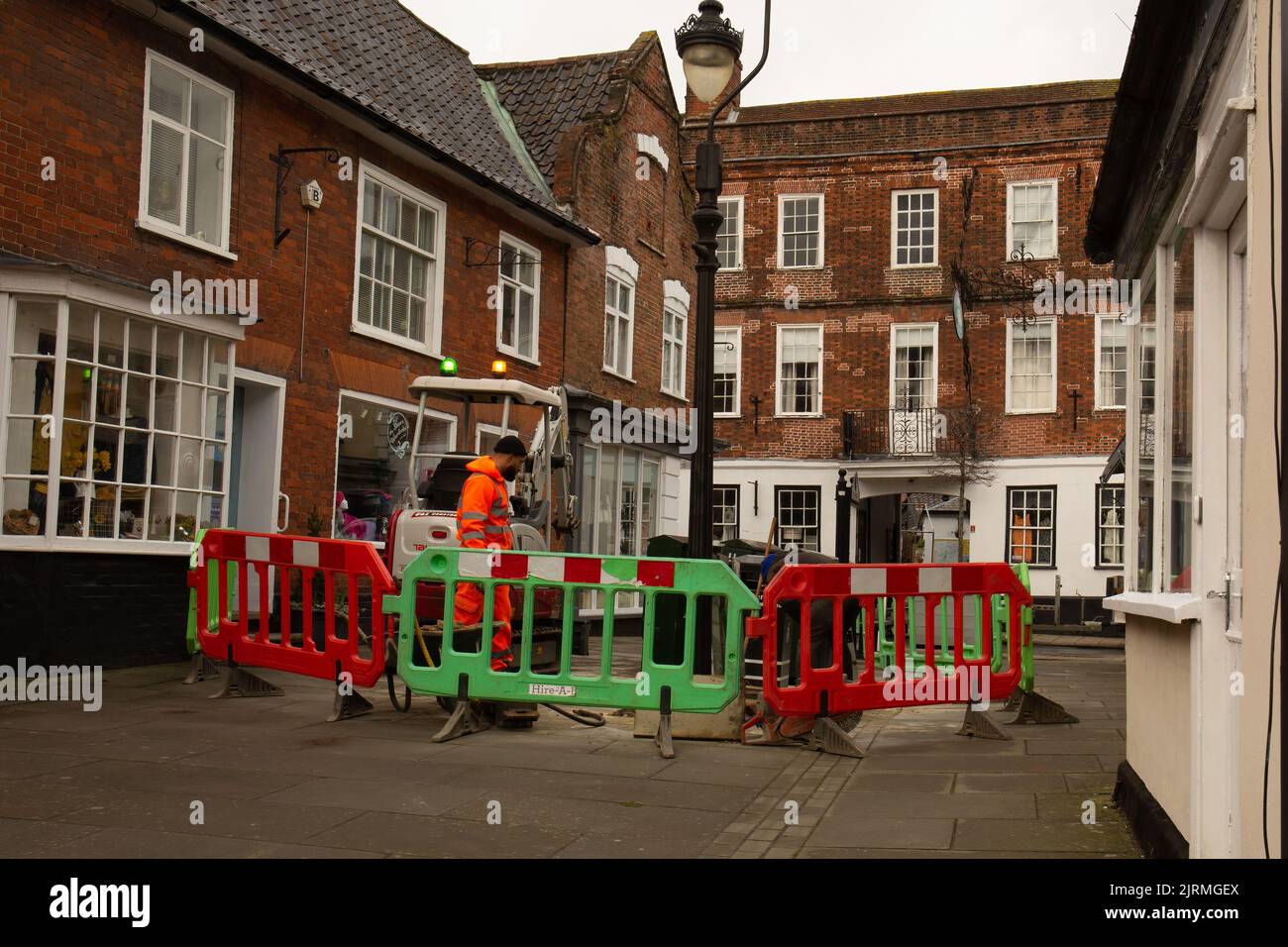 The men working covered with temporary barriers in a narrow street ...