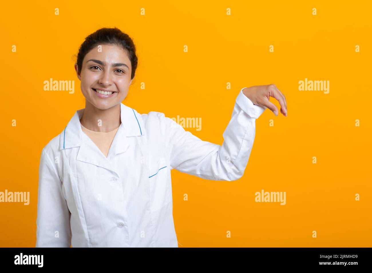 Portrait of indian doctor woman in white medical gown holding fingers ...
