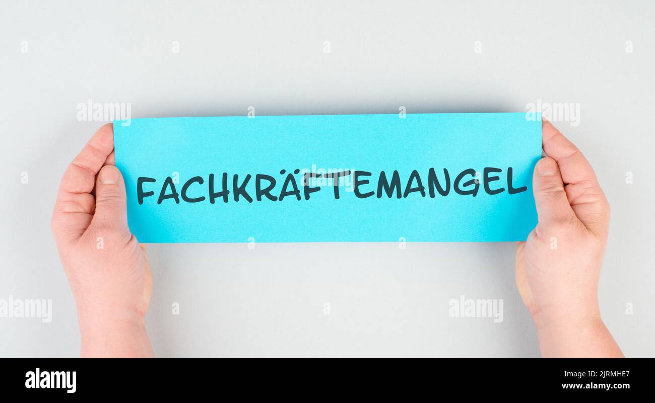 The word skills shortage is standing in german language on the paper ...
