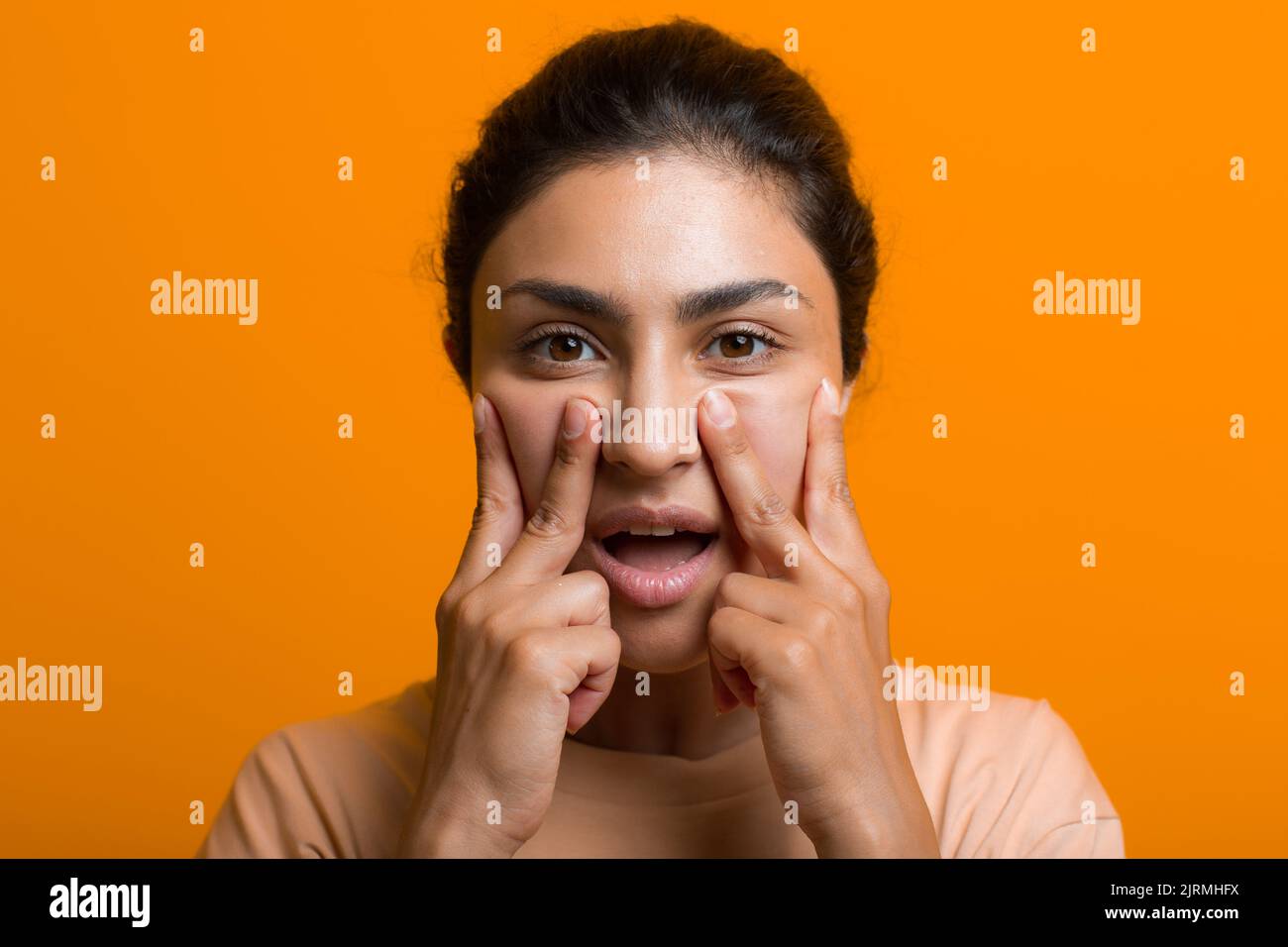 Close up portrait of young indian american woman doing facebuilding ...