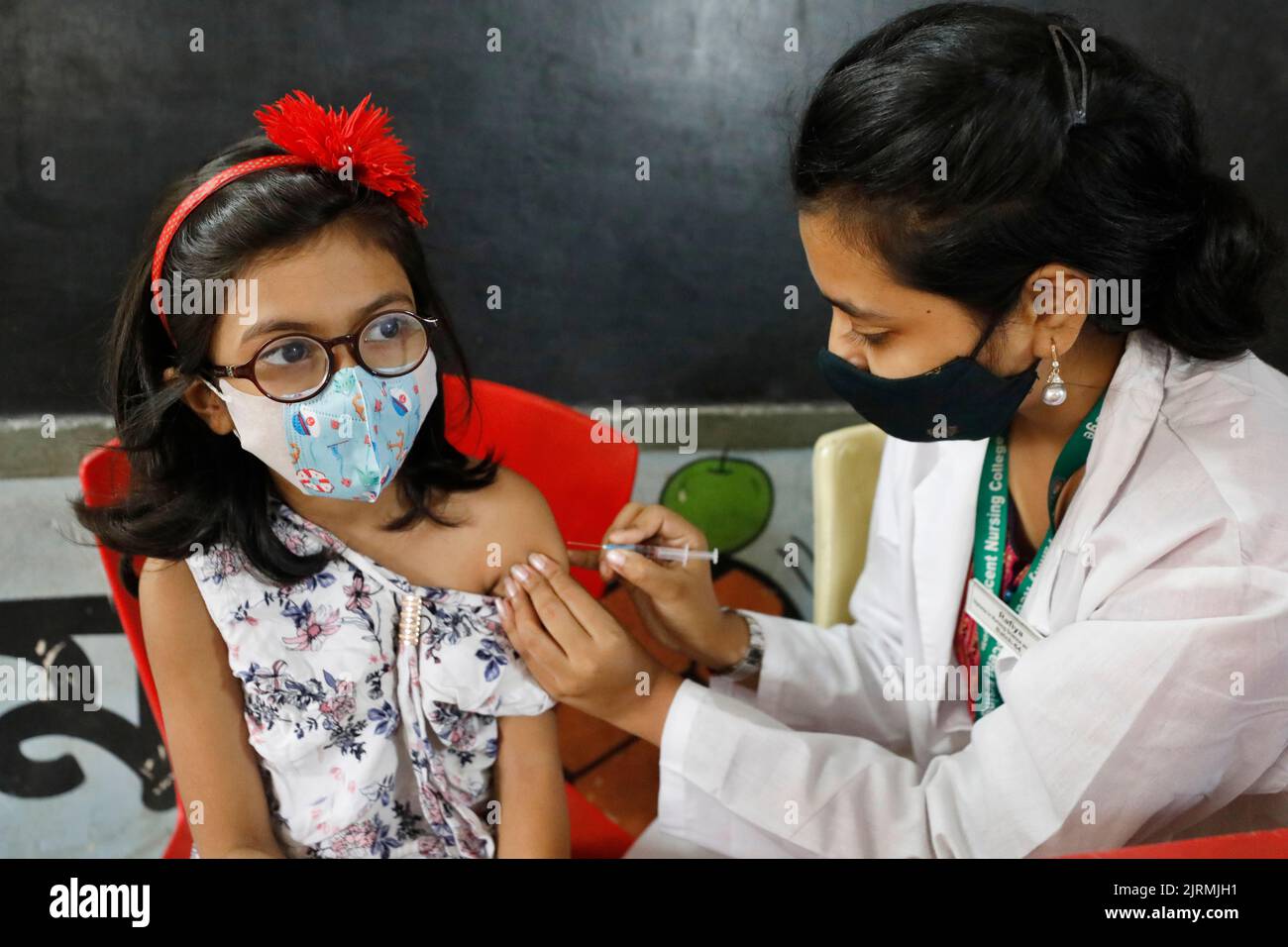 Dhaka, Bangladesh - August 25, 2022: A child gets his first dose of the COVID-19 vaccine at ...