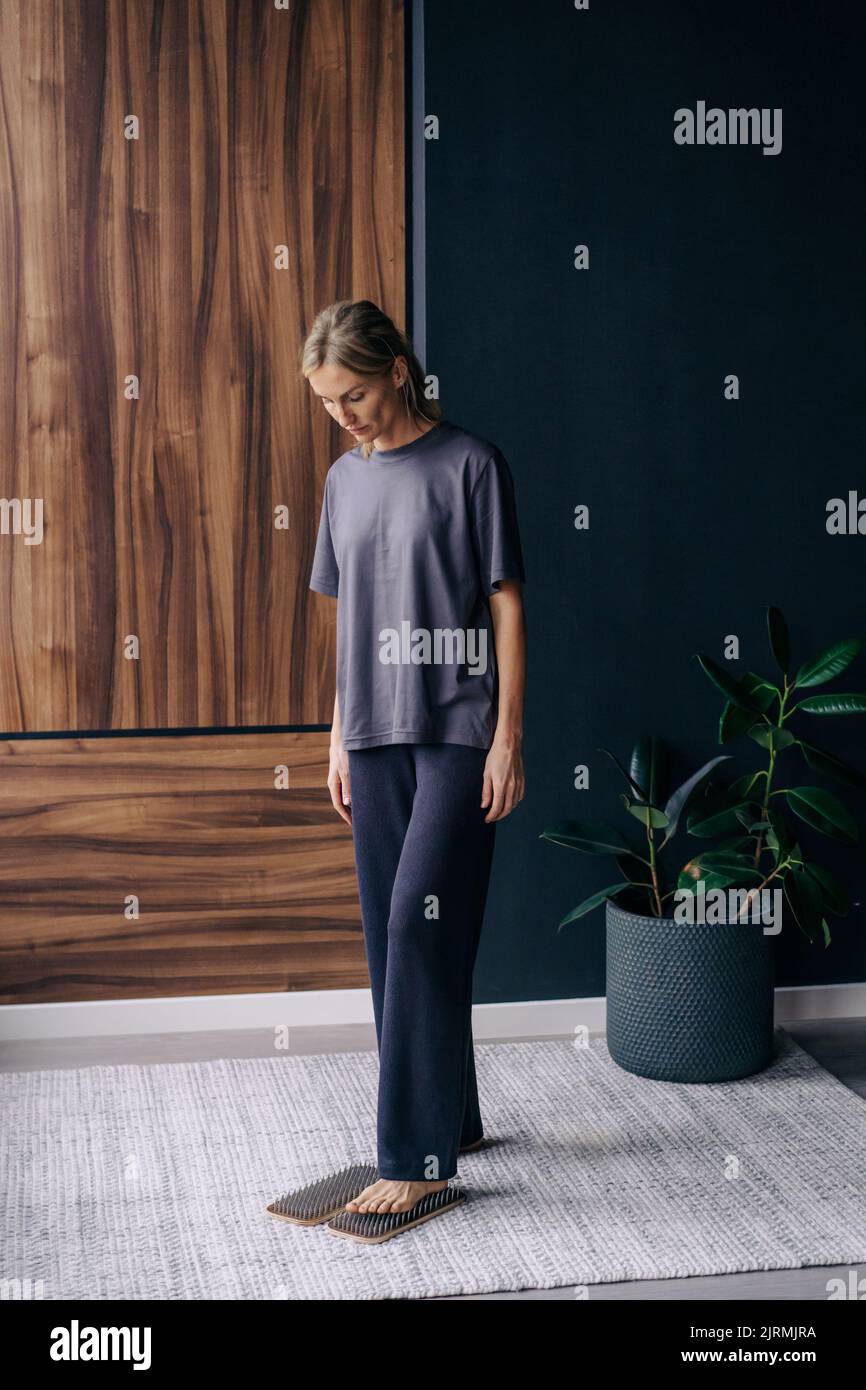 A woman steps barefoot on a sadhu board with nails.Practice of standing ...