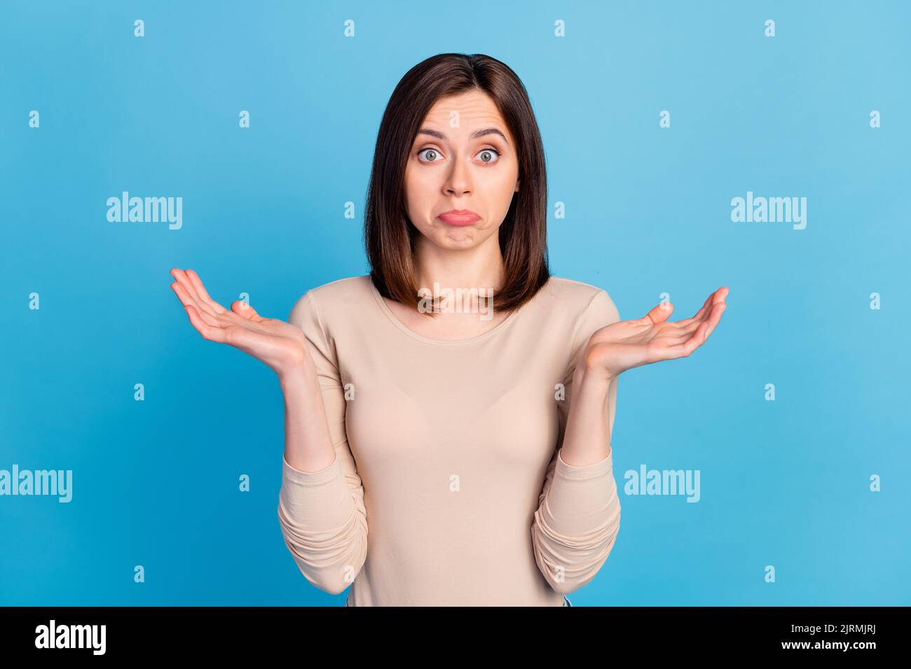 Photo of doubtful young lady raise opened hands palms shrug shoulders ...
