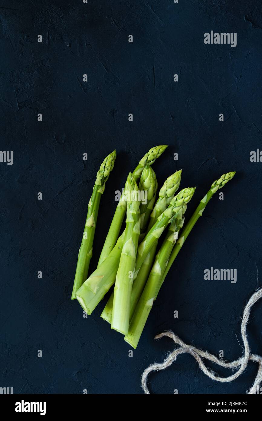 Raw organic green asparagus ready to cook on dark background, top view ...