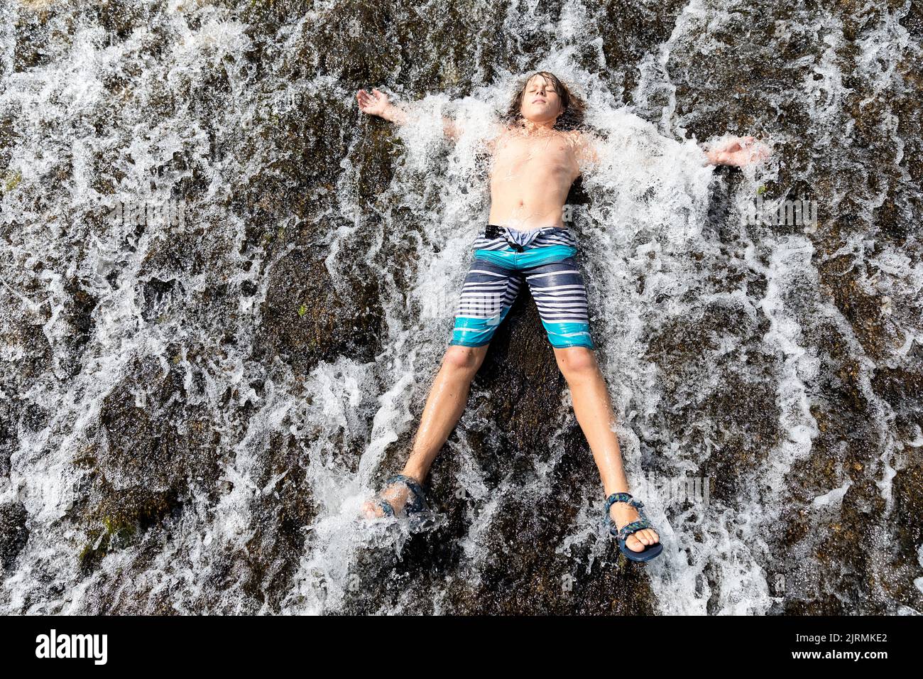 Boy enjoying on in the water on a water dam on a hot and sunny summer ...