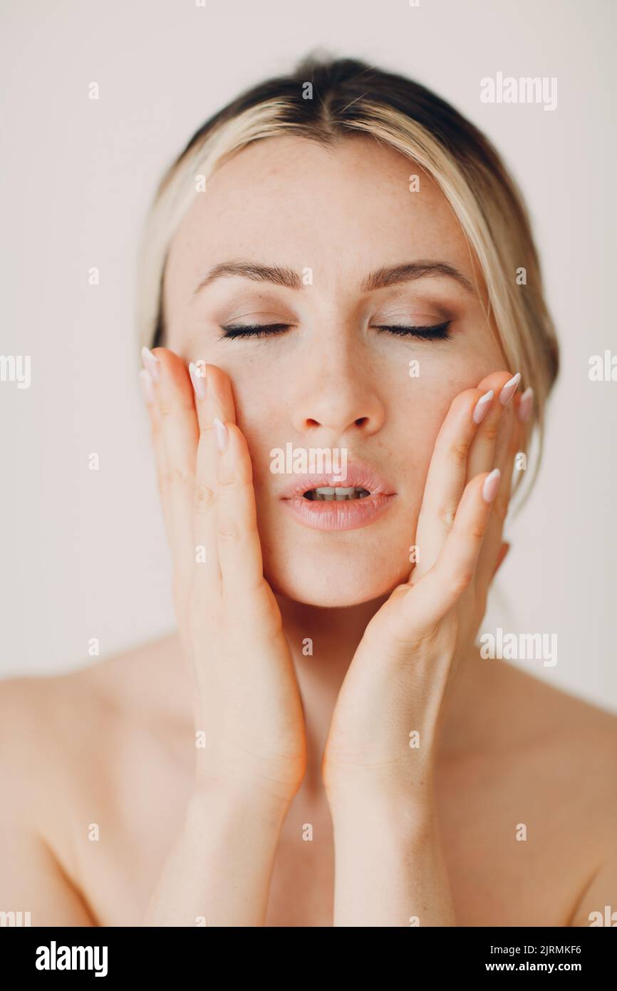 Young adult doing facial gymnastics self massage and rejuvenating ...