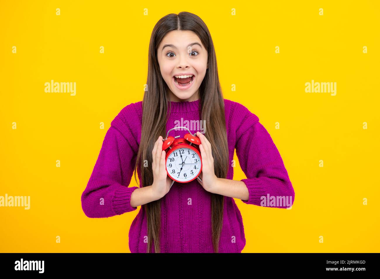 Excited face. Teen student girl hold clock isolated on yellow ...