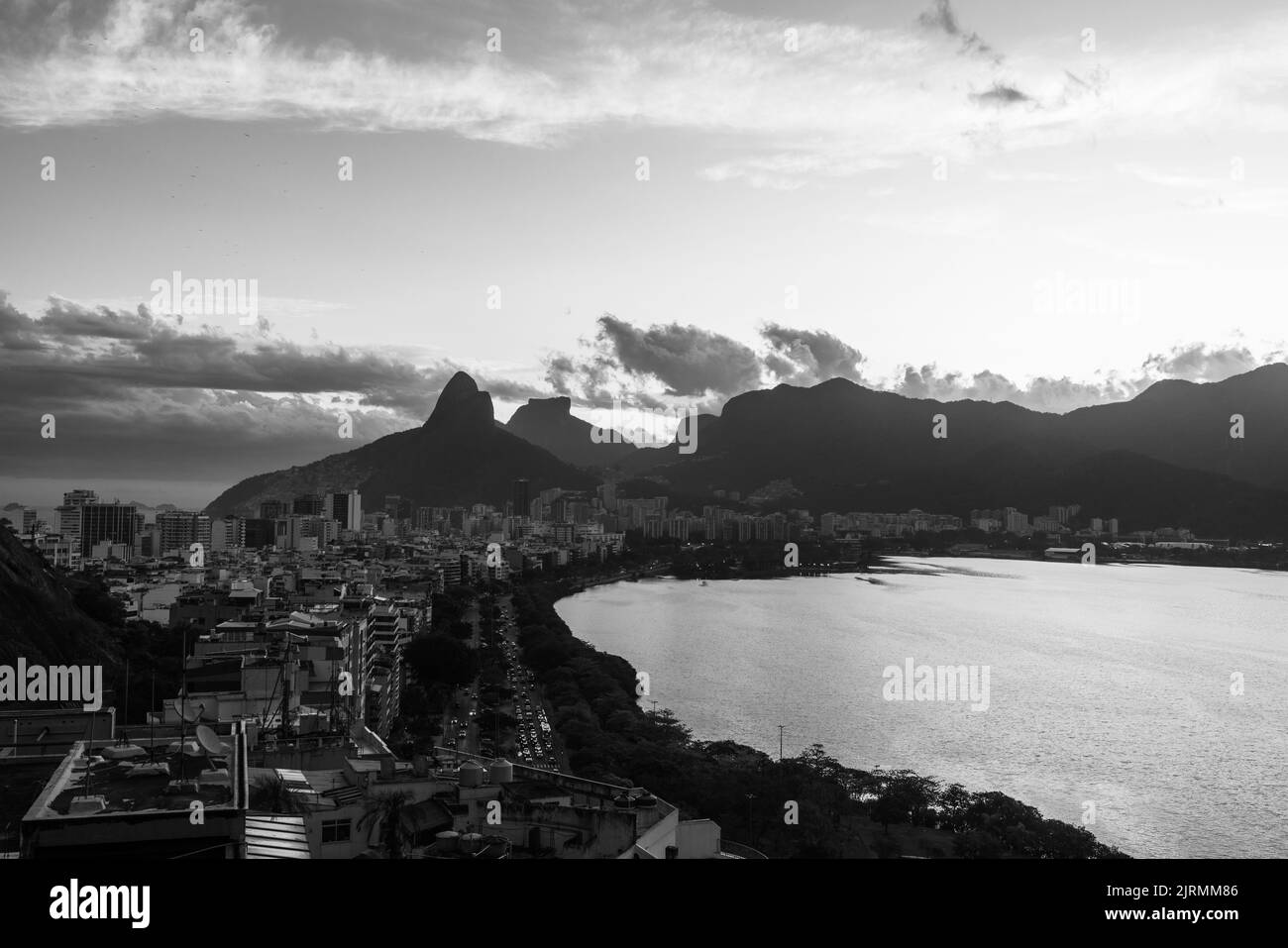 A grayscale of the coastline tropical city buildings and mountains of ...