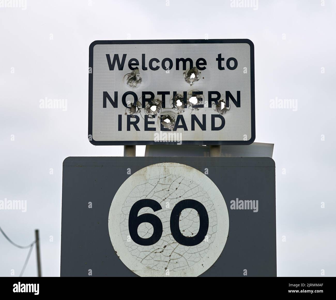 A welcome to Northern Ireland sign riddled with large bullet holes ...