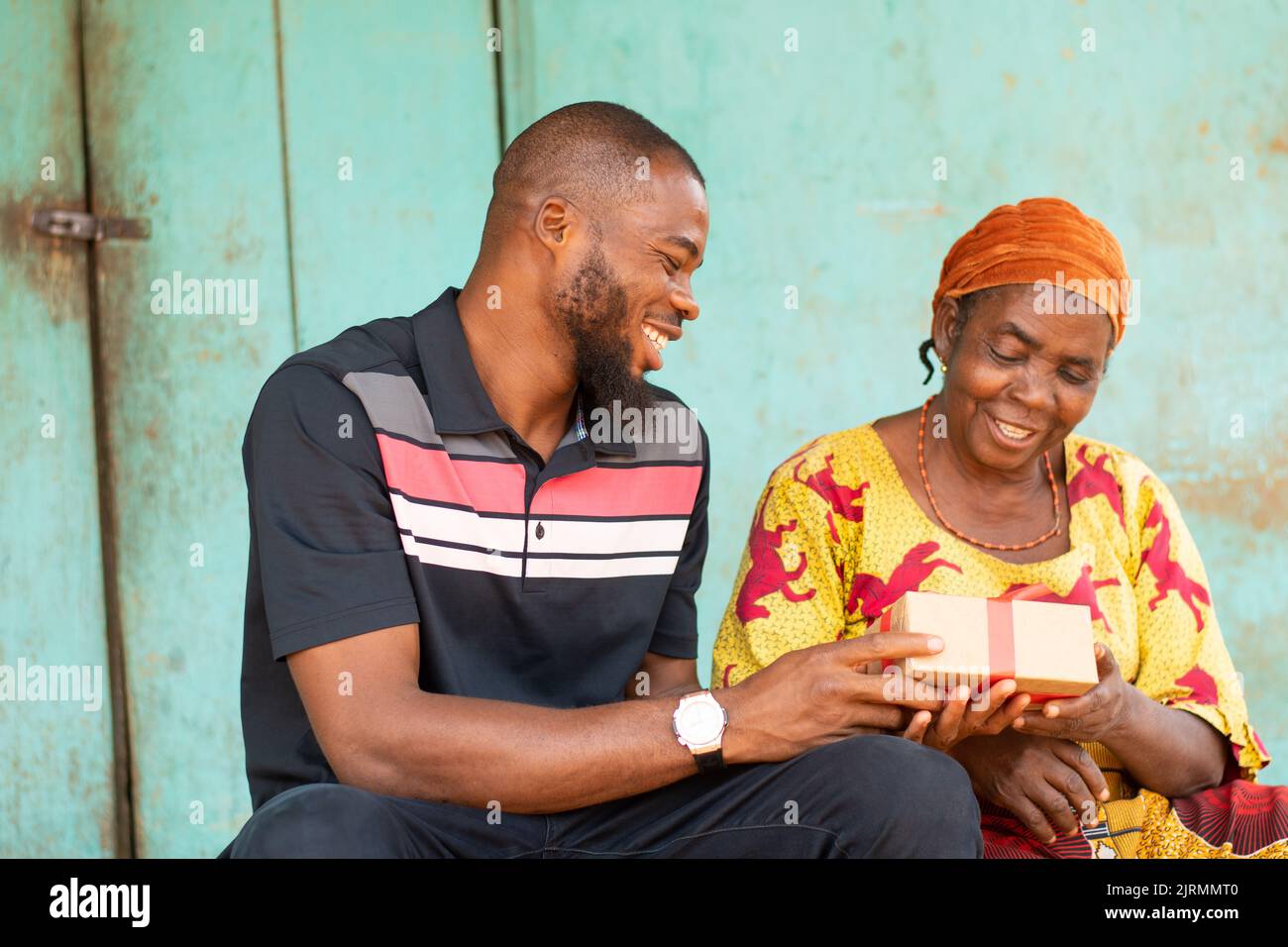 young african man gives an old black woman a gift Stock Photo - Alamy