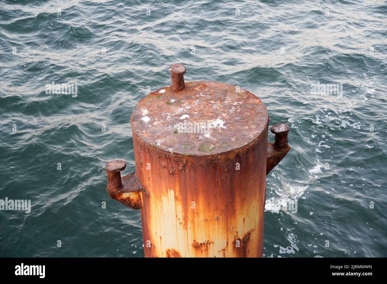 A closeup of a pile mooring with blue water in the background Stock ...
